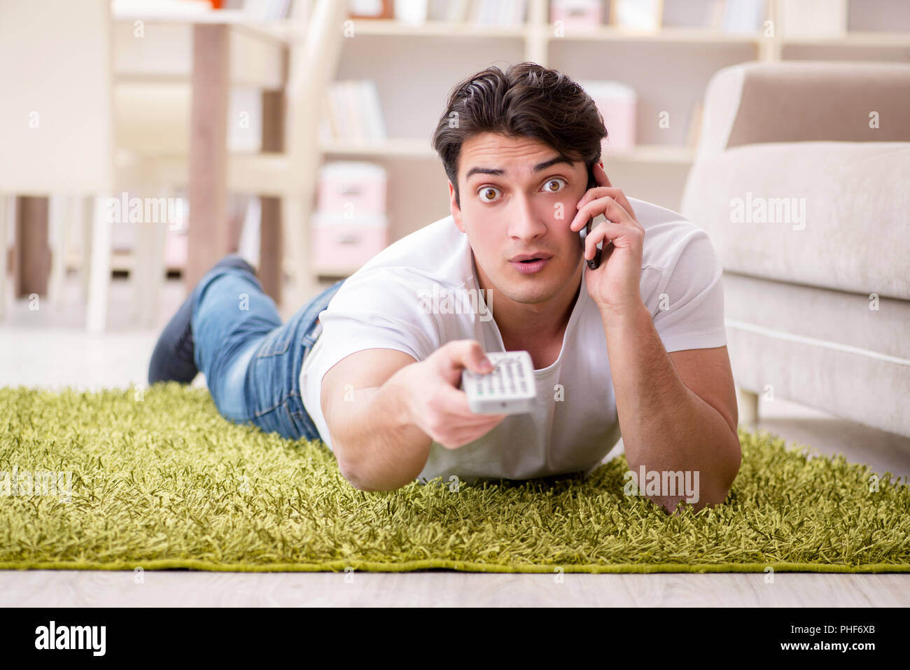 Man watching tv at home on floor Stock Photo - Alamy