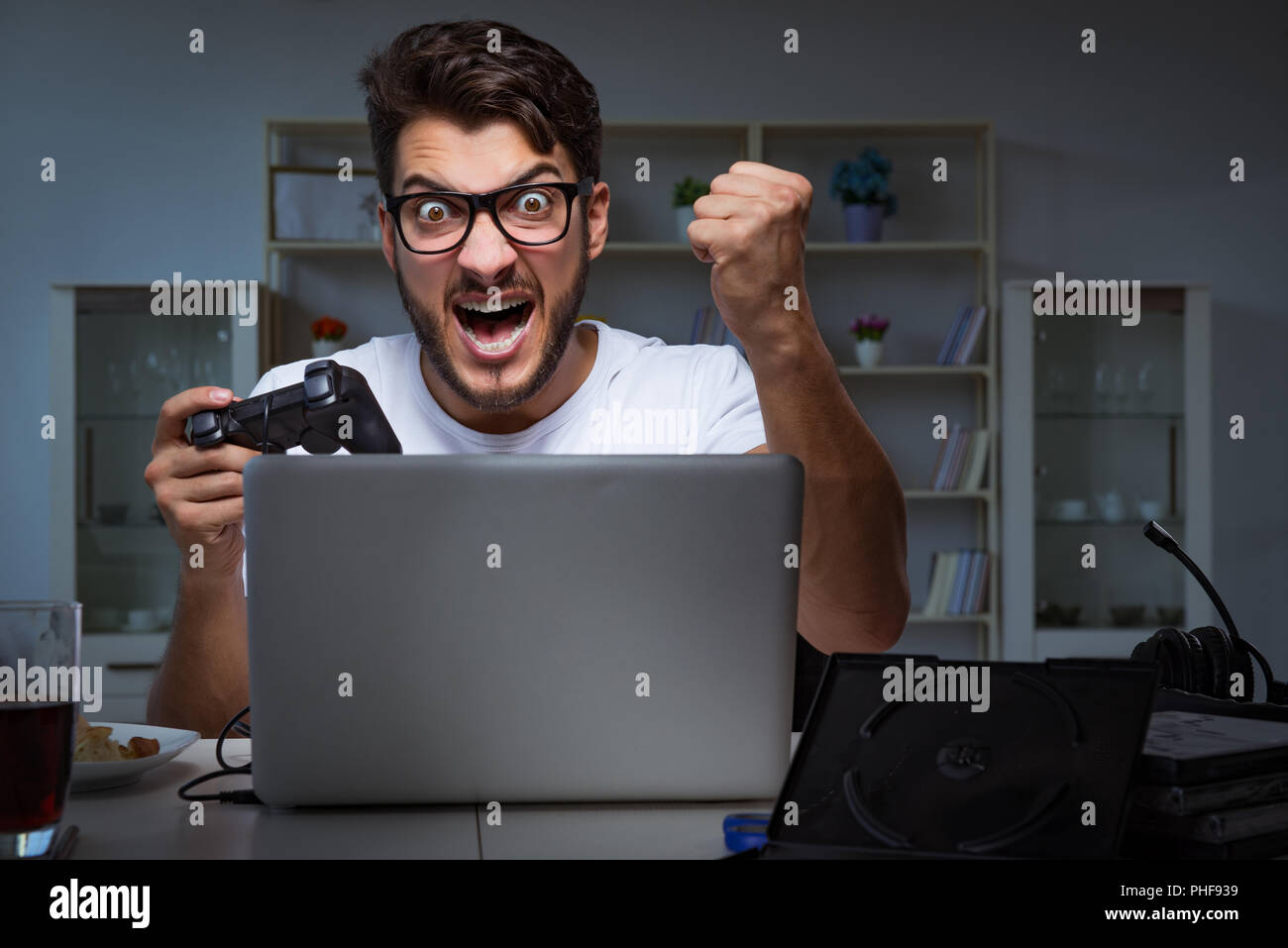 Young man playing games long hours late in the office Stock Photo - Alamy