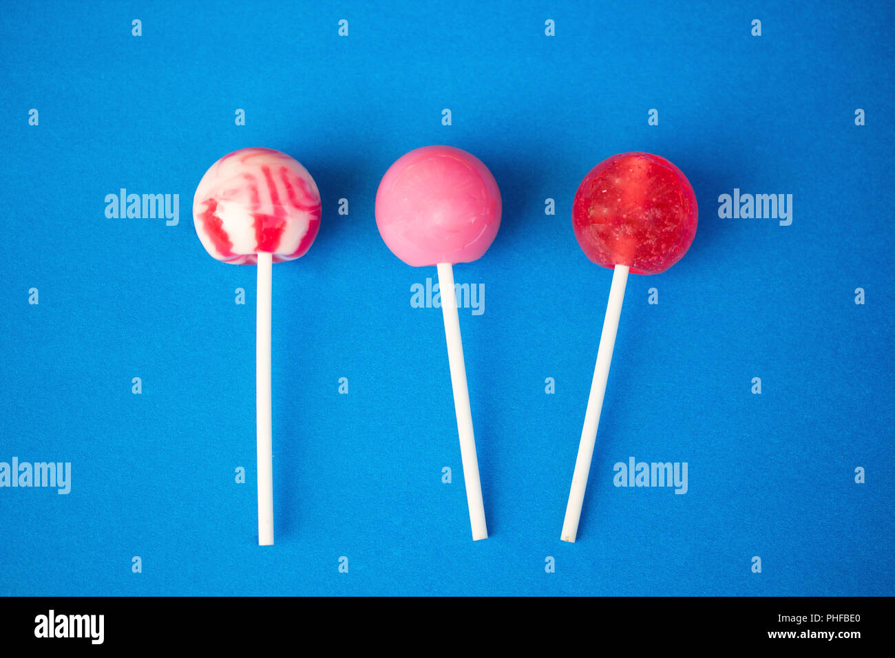 lollipops on a bright blue background Stock Photo - Alamy