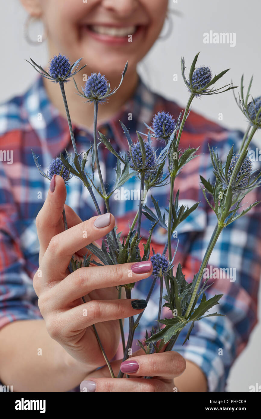 girl holding blue flowers eryngium Stock Photo - Alamy
