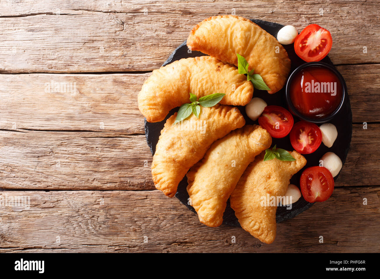 fried panzerotti with a filling of tomatoes, herbs and mozzarella close ...