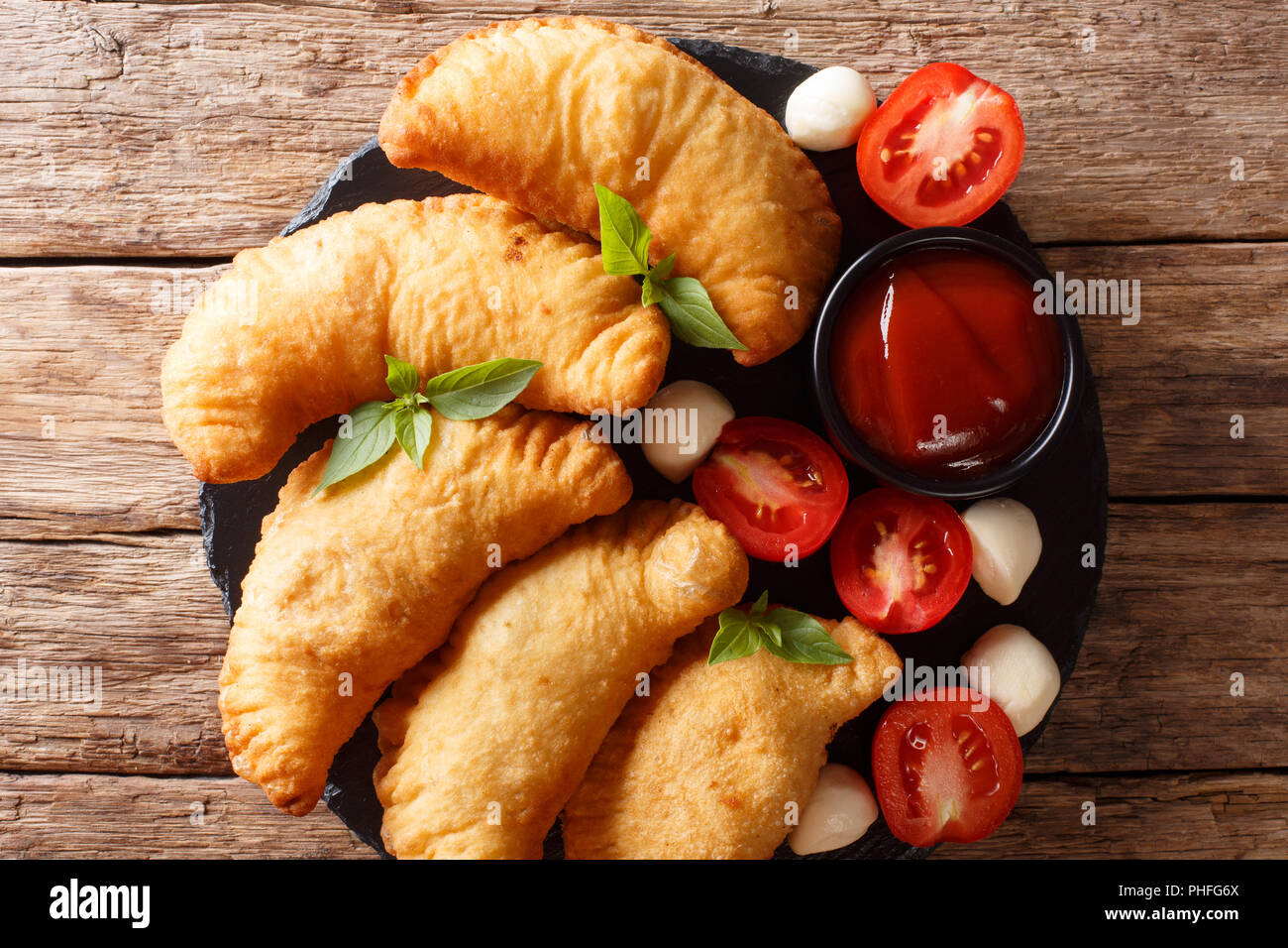 Spicy typical street Italian food: fried panzerotti with tomato sauce ...