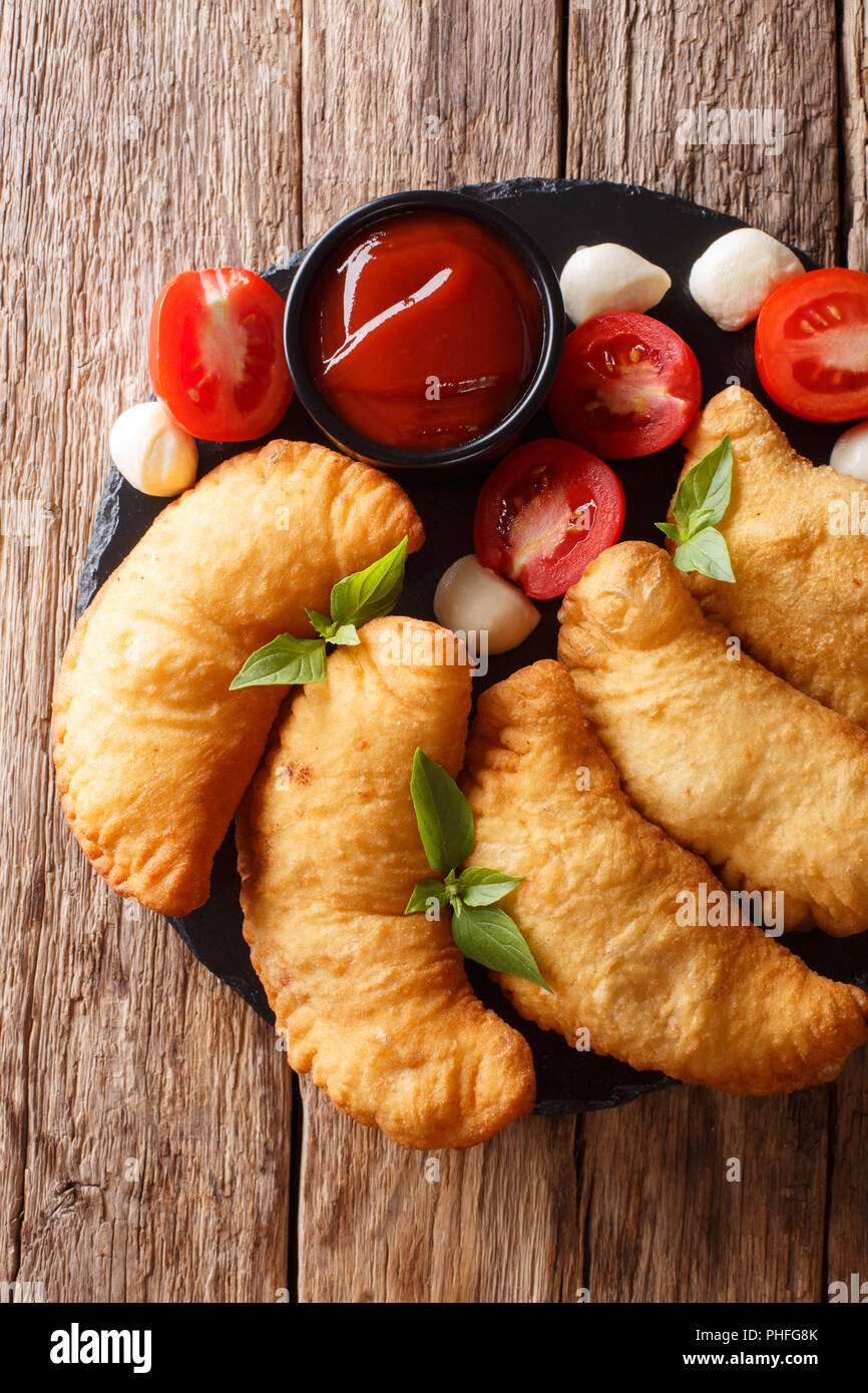 Spicy typical street Italian food: fried panzerotti with tomato sauce ...