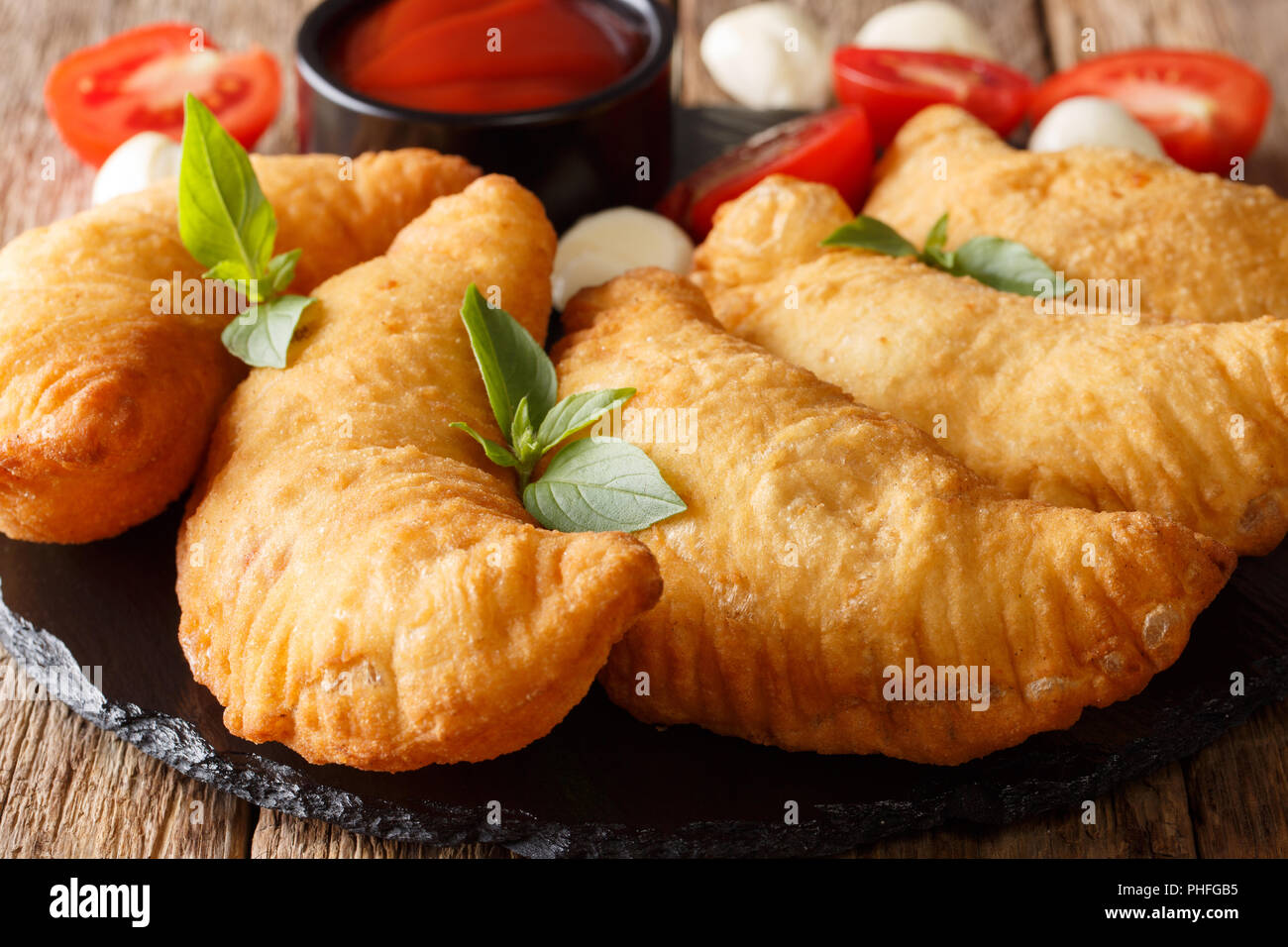Italian fast food: fried panzerotti with tomato sauce, herbs and ...