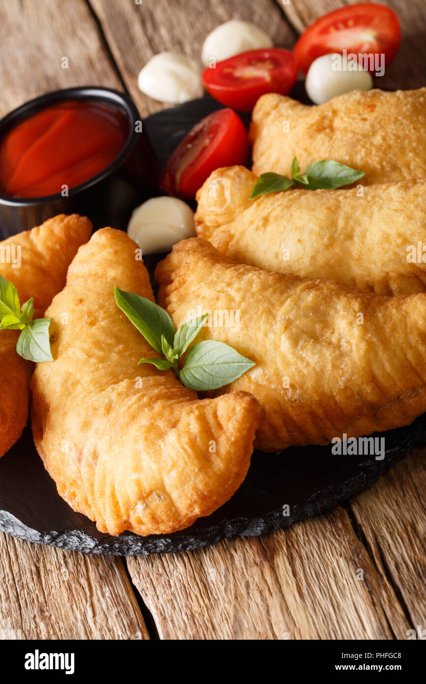 Italian deep-fried panzerotto with tomato sauce and mozzarella closeup ...