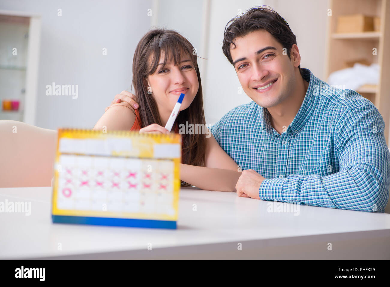 Young family in pregnancy planning concept with ovulation calendar ...