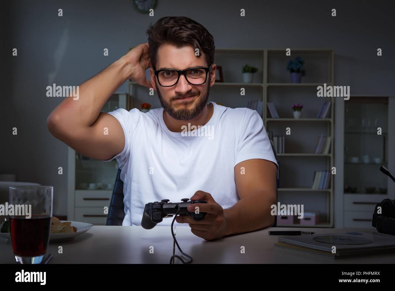 Young man playing games long hours late in the office Stock Photo - Alamy
