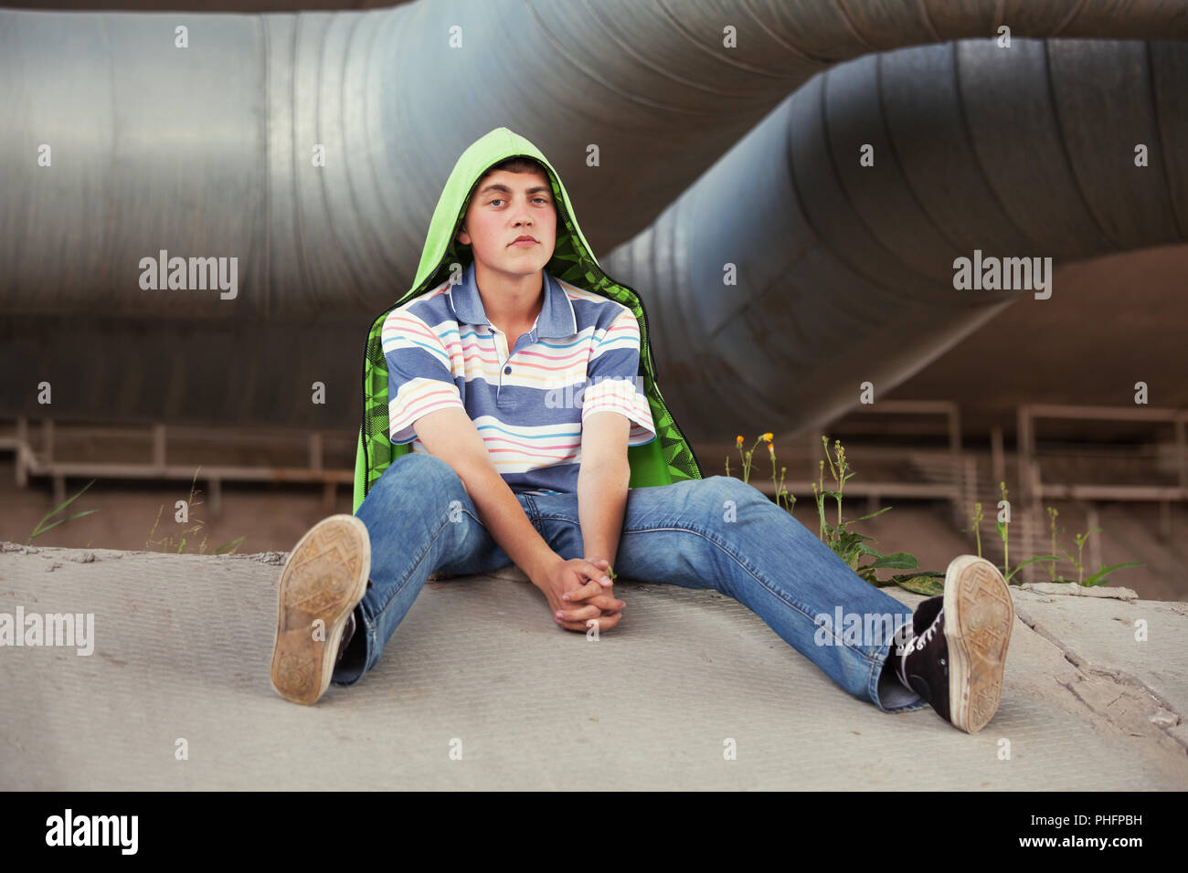 Sad teen boy in depression sitting on the ground outdoor Stock Photo ...