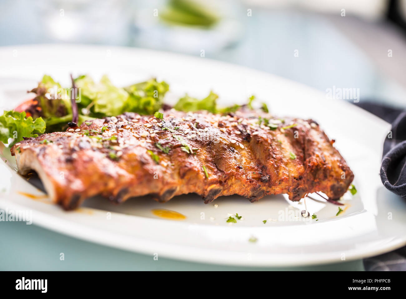 Grilled barbecue pork ribs in a white plate as menu in pub or ...