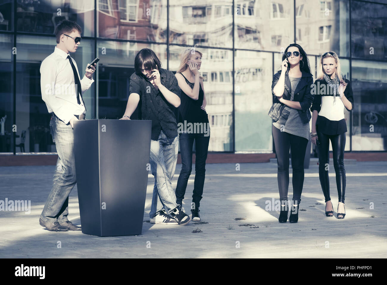Young fashion people talking on cell phones in city street Stock Photo ...