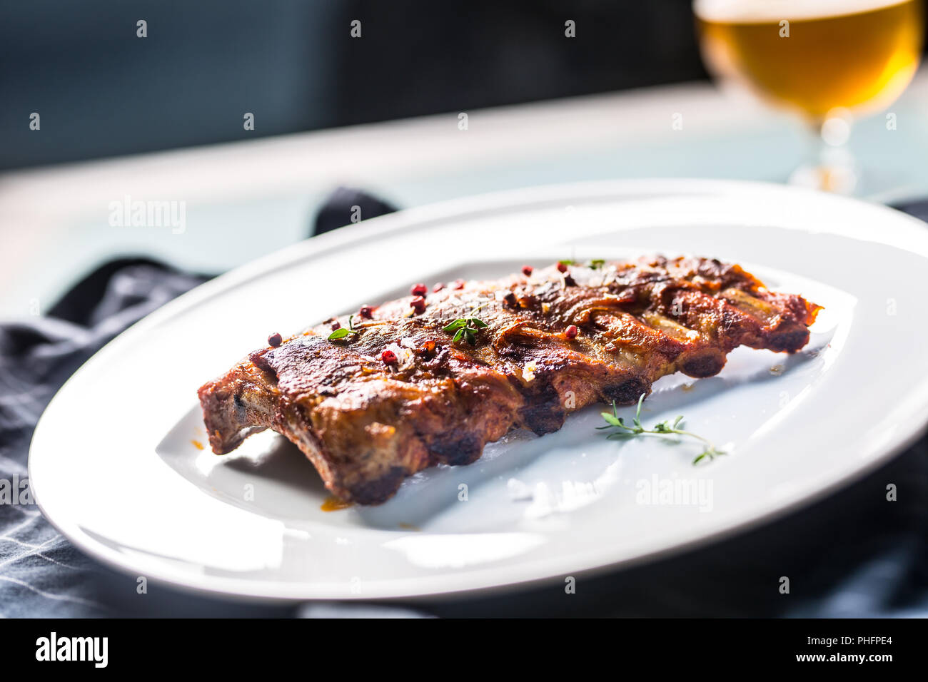 Grilled barbecue pork ribs in a white plate as menu in pub or ...
