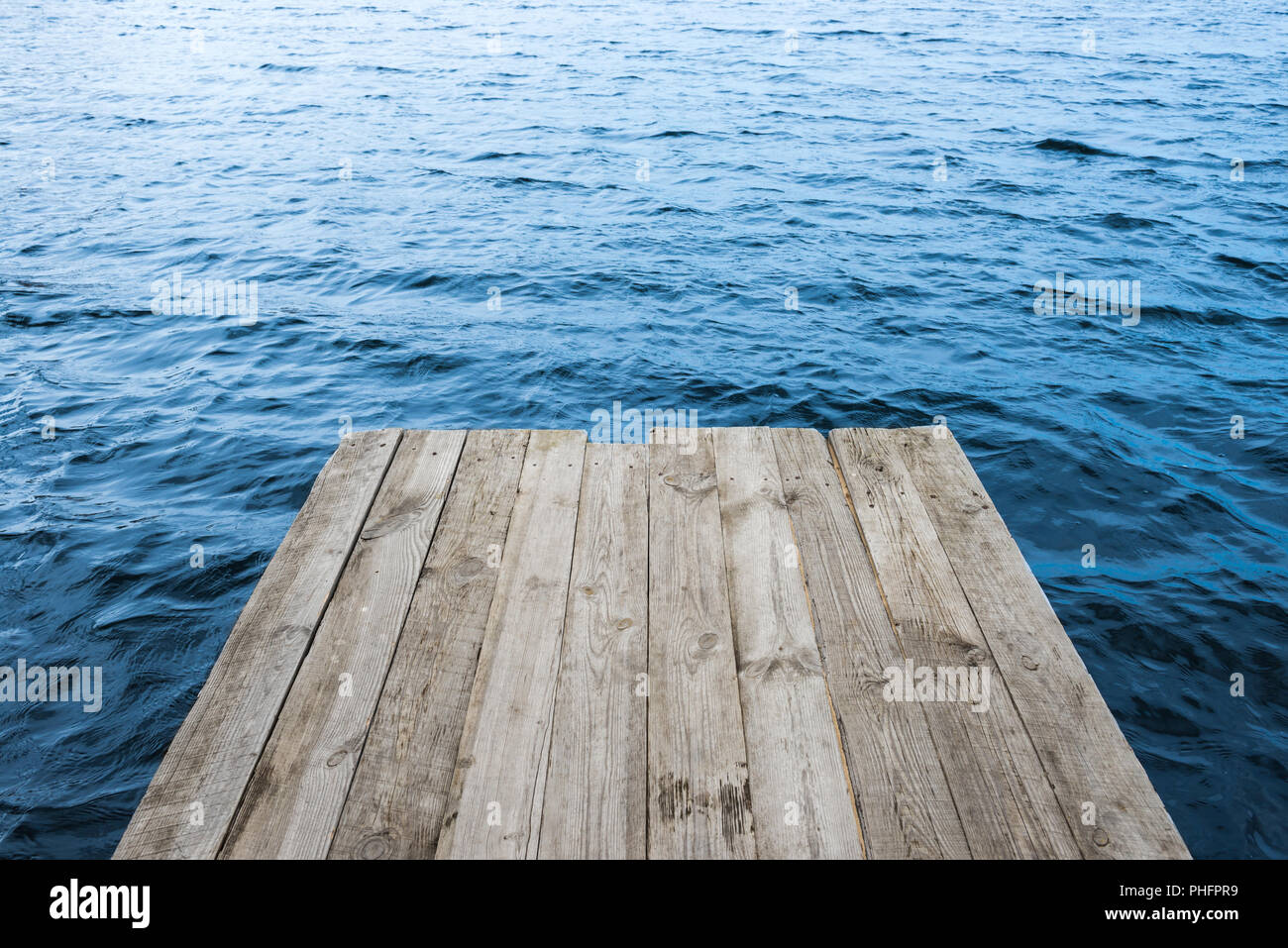 Blue water with empty wooden platform Stock Photo - Alamy