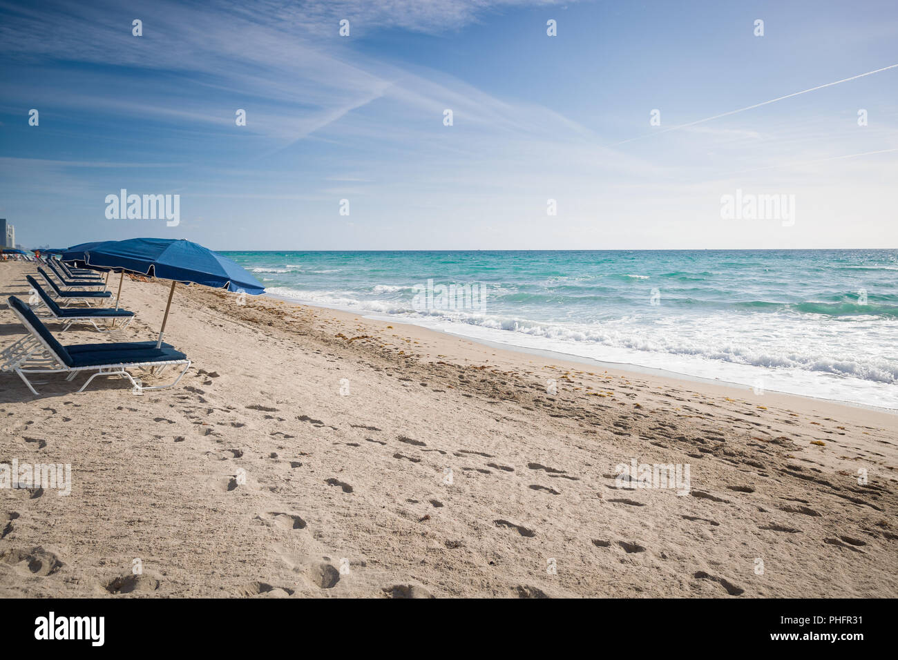 Beach in Miami, FL. Open umbrellas on the sand beach at the ocean ...