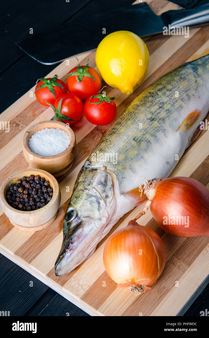 Uncooked fish on cutting board in meal preparation concept Stock Photo ...