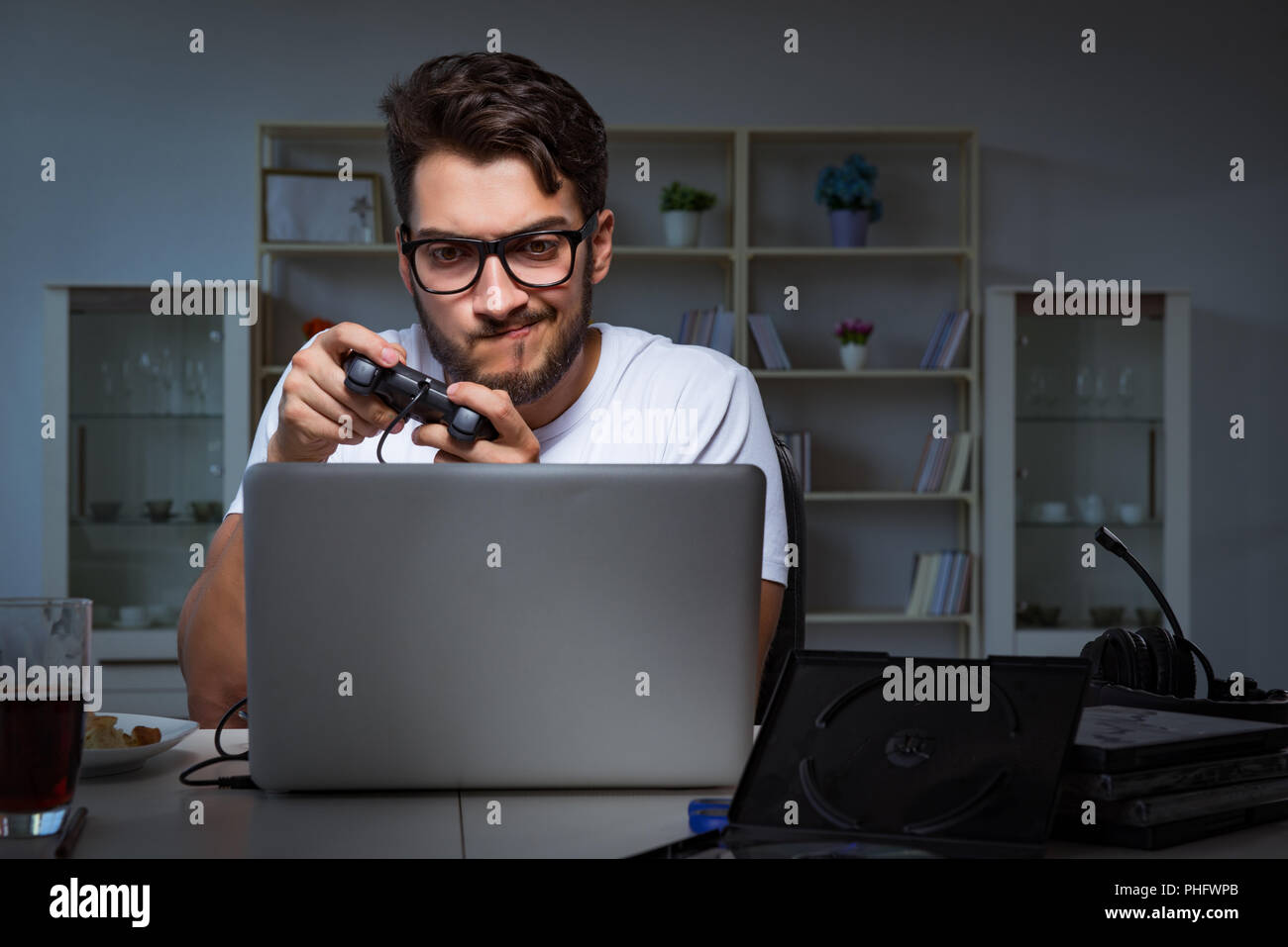 Young man playing games long hours late in the office Stock Photo - Alamy