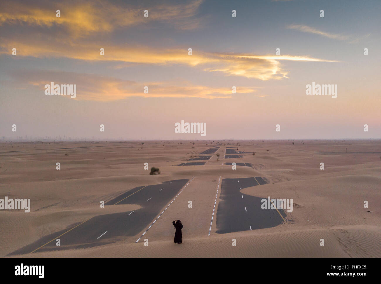 woman in a traditional emirati dress called abaya in a desert near ...