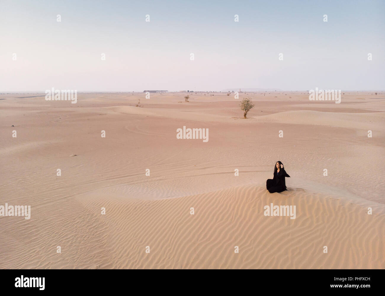 woman in a traditional emirati dress called abaya in a desert near ...