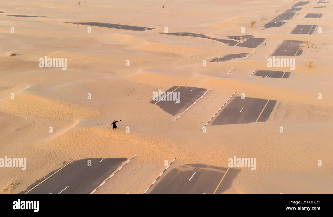 woman in a traditional emirati dress called abaya in a desert near ...