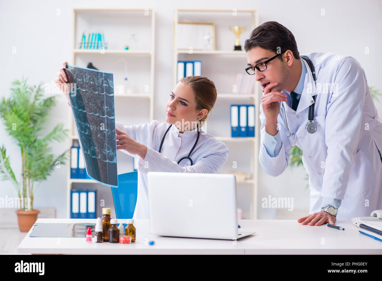 Two doctors examining x-ray images of patient for diagnosis Stock Photo ...