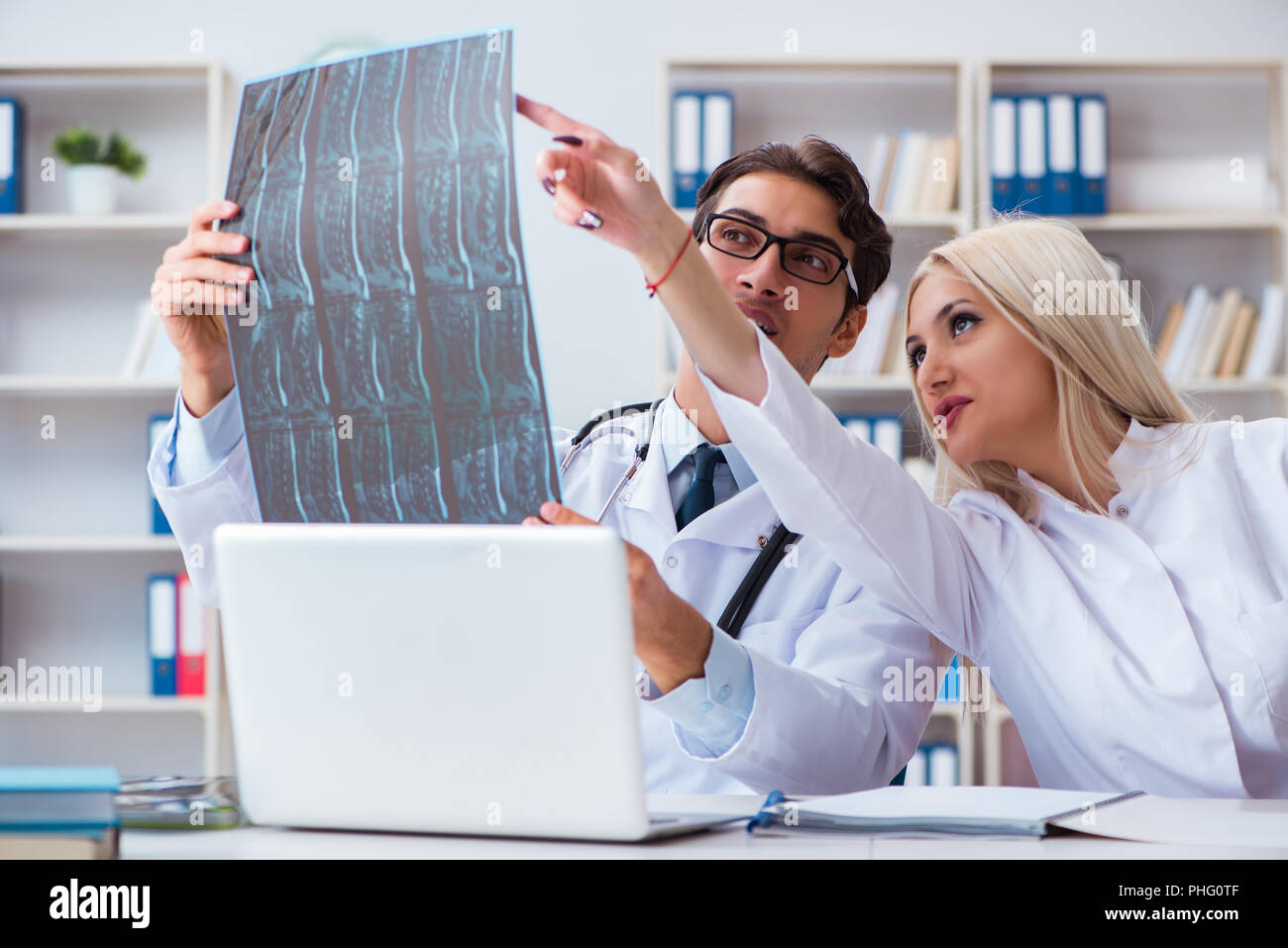 Two doctors examining x-ray images of patient for diagnosis Stock Photo ...
