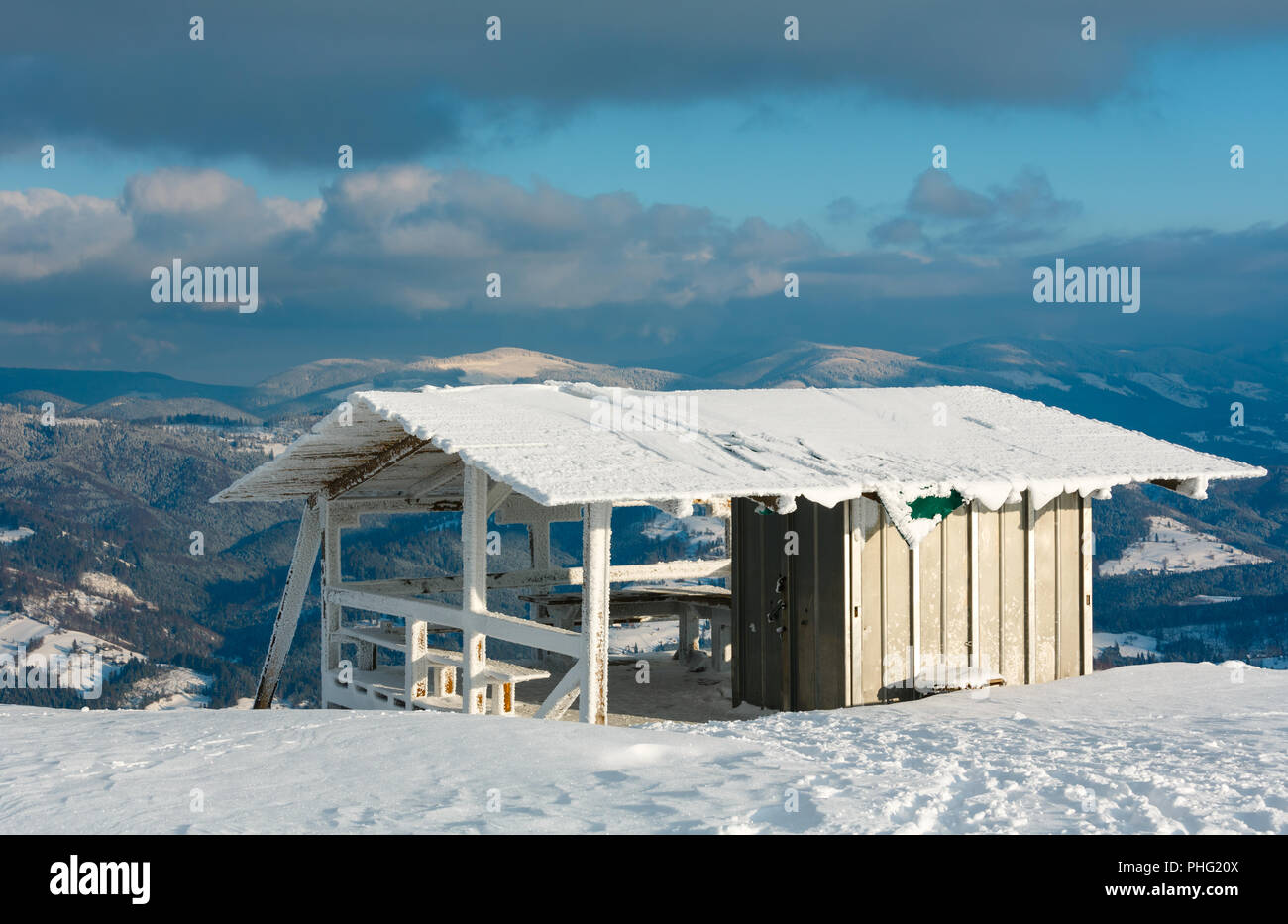 Winter mountain snowy landscape with small wooden platform and cabin ...