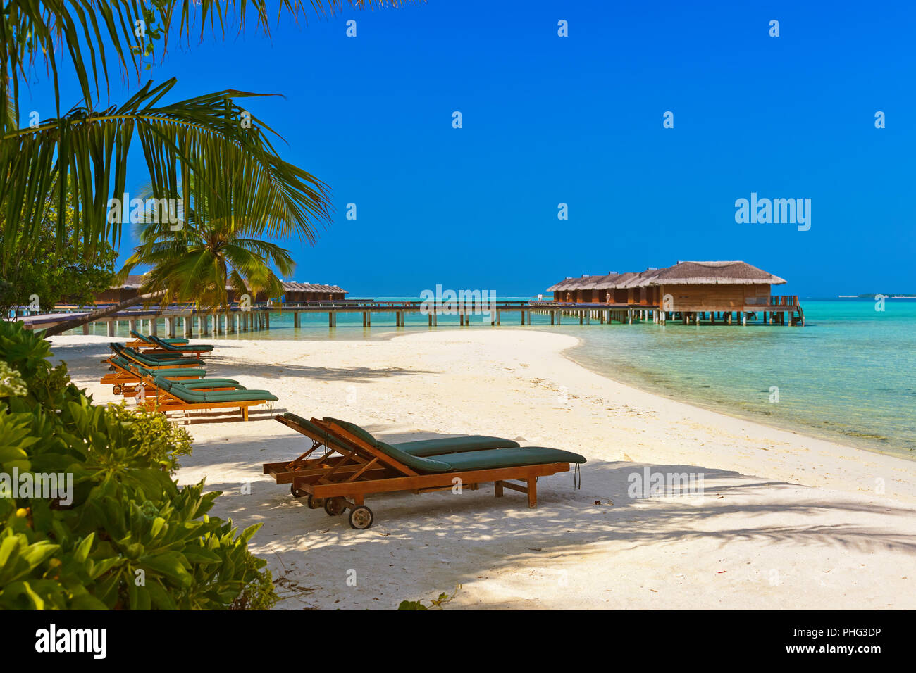 Loungers on Maldives beach Stock Photo - Alamy