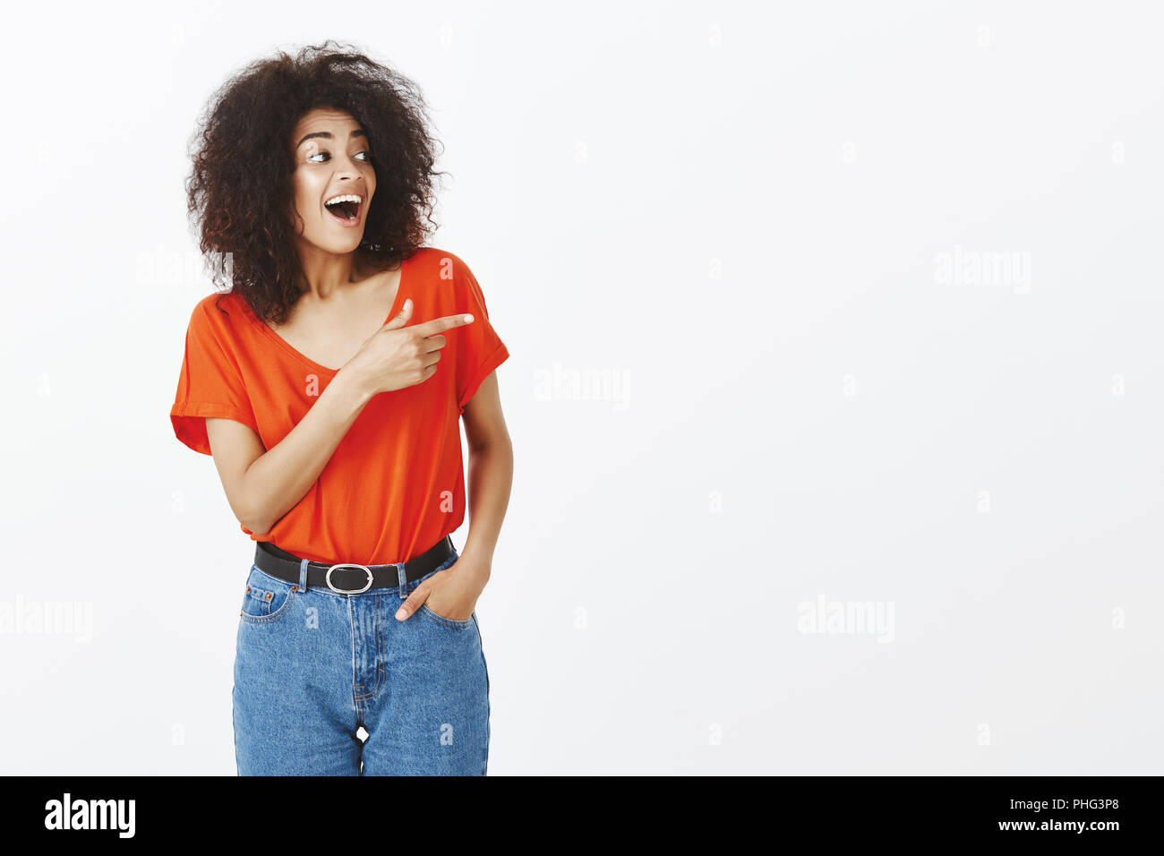 Indoor shot of amazed happy outgoing woman with dark skin and curly ...