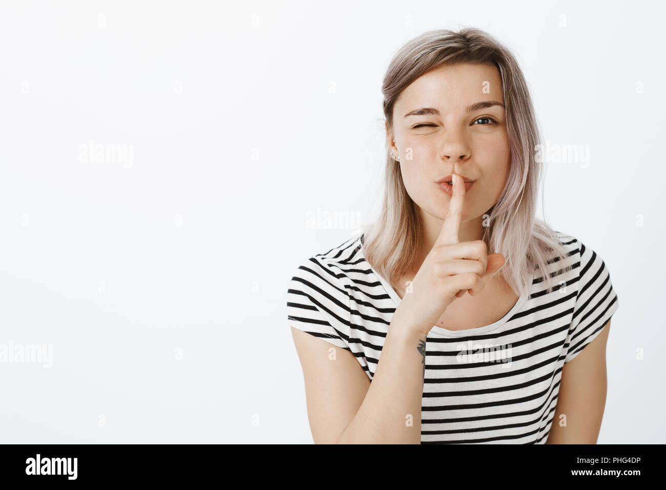 Do not tell anyone what happened. Portrait of attractive playful stylish girl, bending towards ...