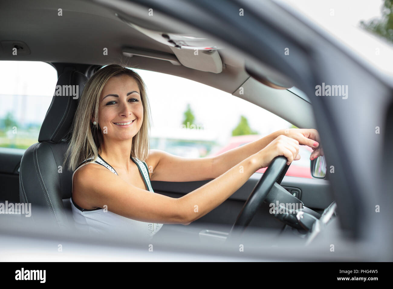 Woman driving a car - female driver at a wheel of a modern car, looking ...