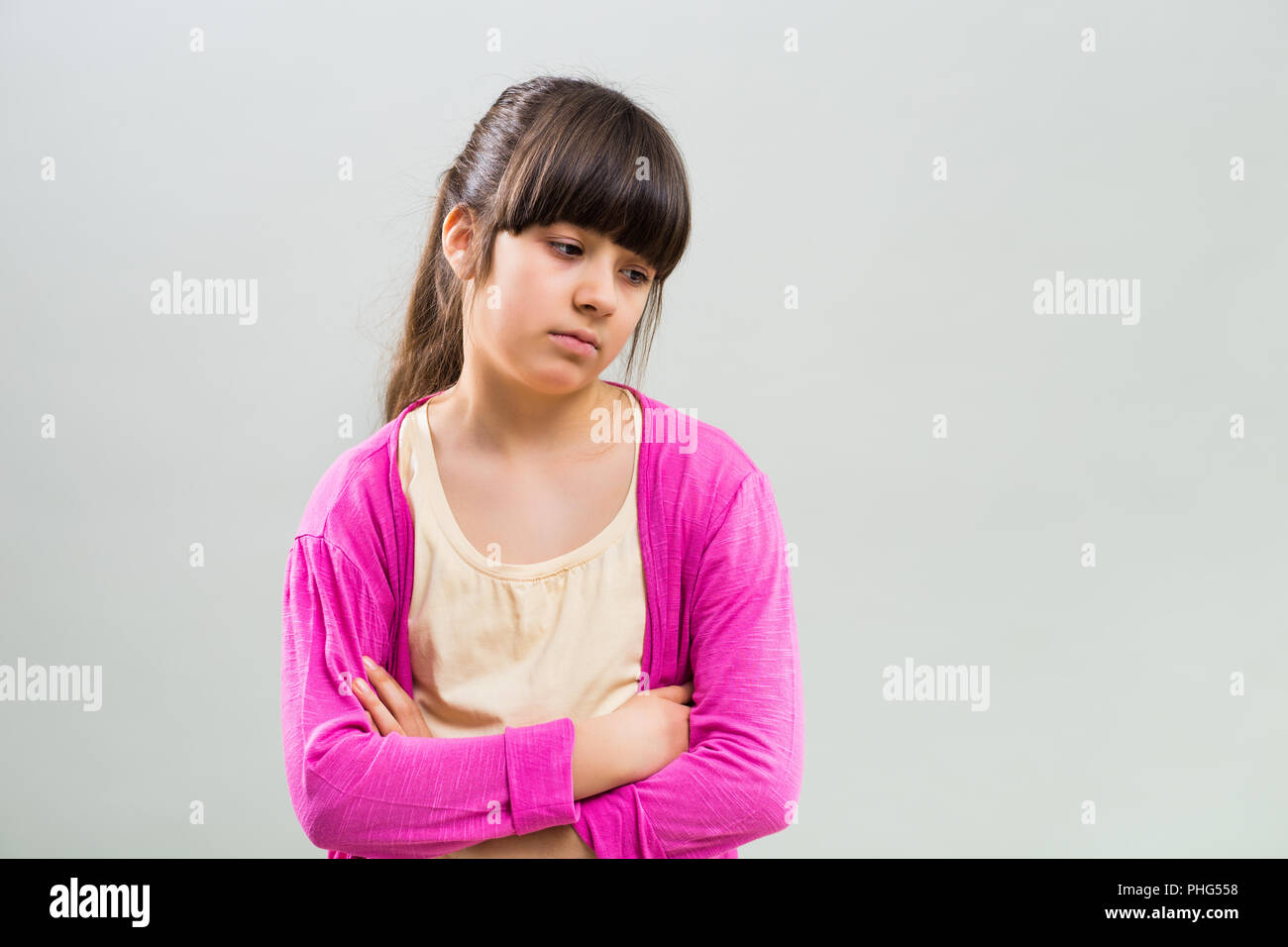Sad little girl on grey background Stock Photo - Alamy
