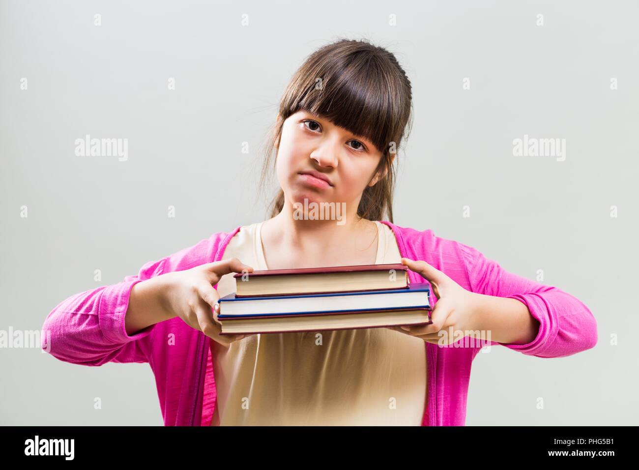 Angry little girl with books Stock Photo - Alamy