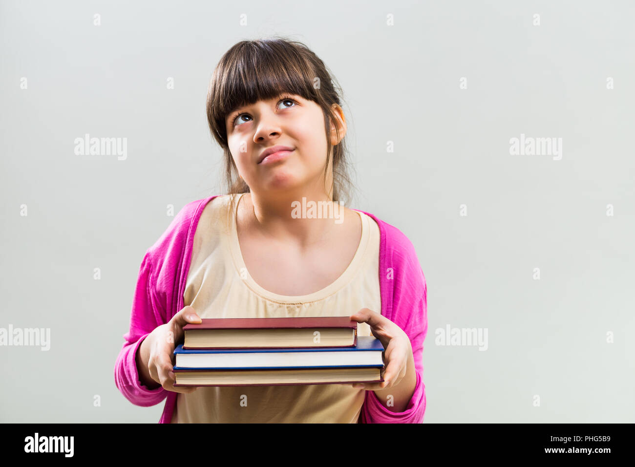 Angry little girl with books Stock Photo - Alamy