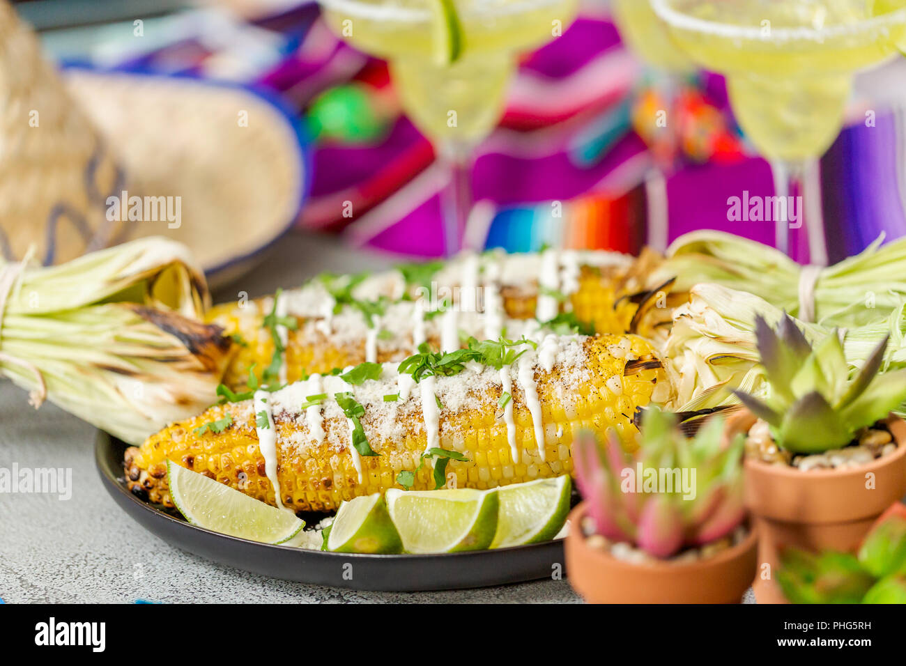 Grilling mexican street corn elote garnished with spices and fresh ...
