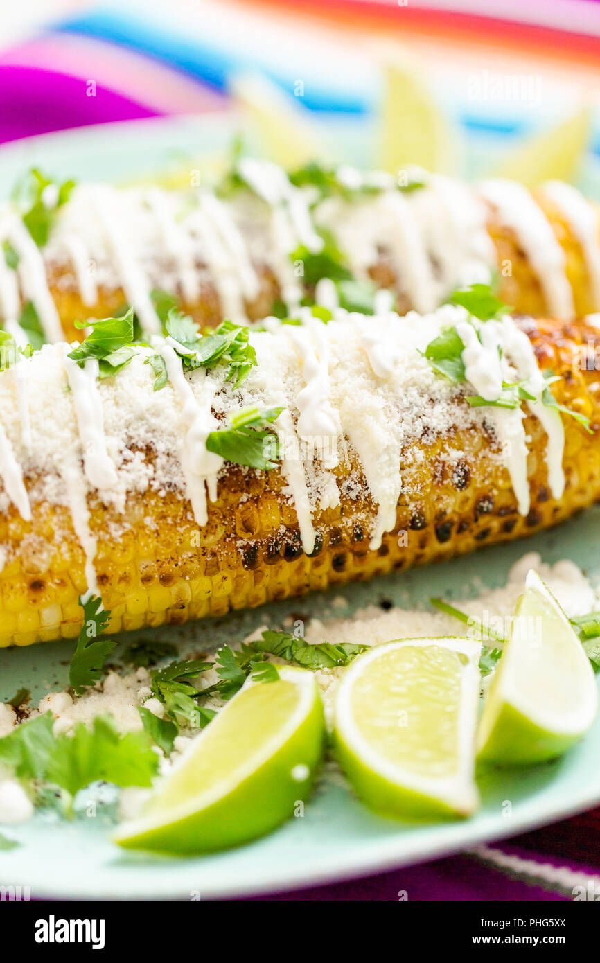 Grilling mexican street corn elote garnished with spices and fresh ...