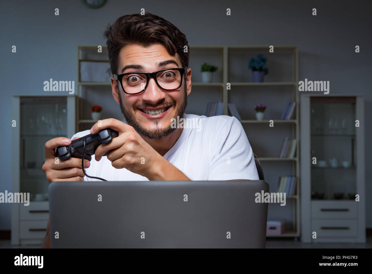 Young man playing games long hours late in the office Stock Photo - Alamy