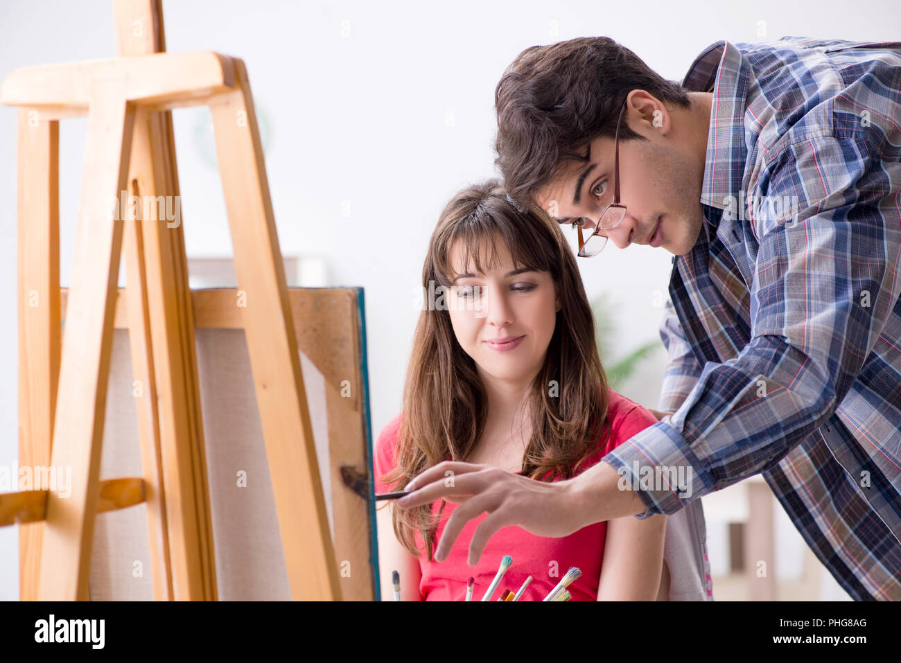 Artist coaching student in painting class in studio Stock Photo - Alamy