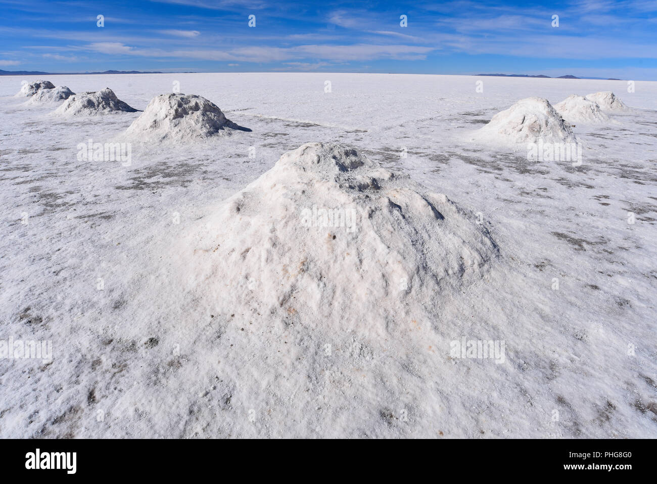 Piles of salt drying in the sun near the mining town of Colcani. Salar ...