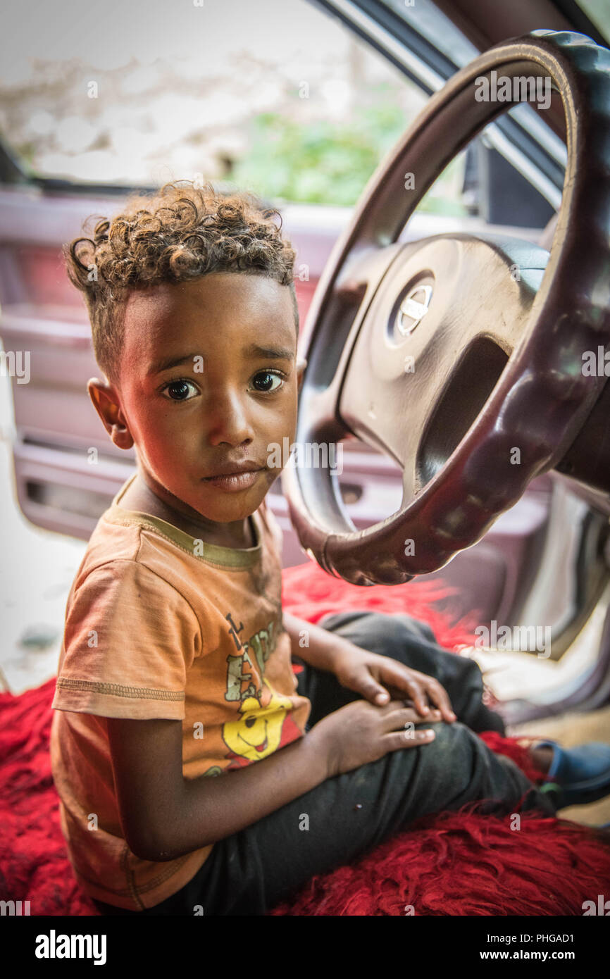 A young Bilen boy jumps in the driver's seat of a waiting jeep in Keren ...