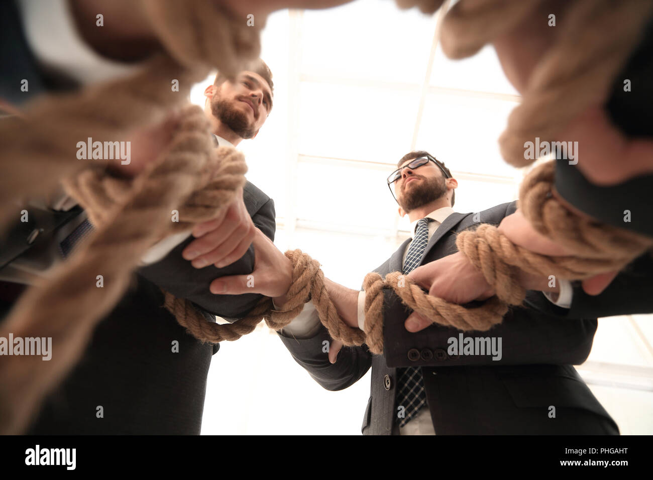 closeup.business team holding strong rope Stock Photo - Alamy