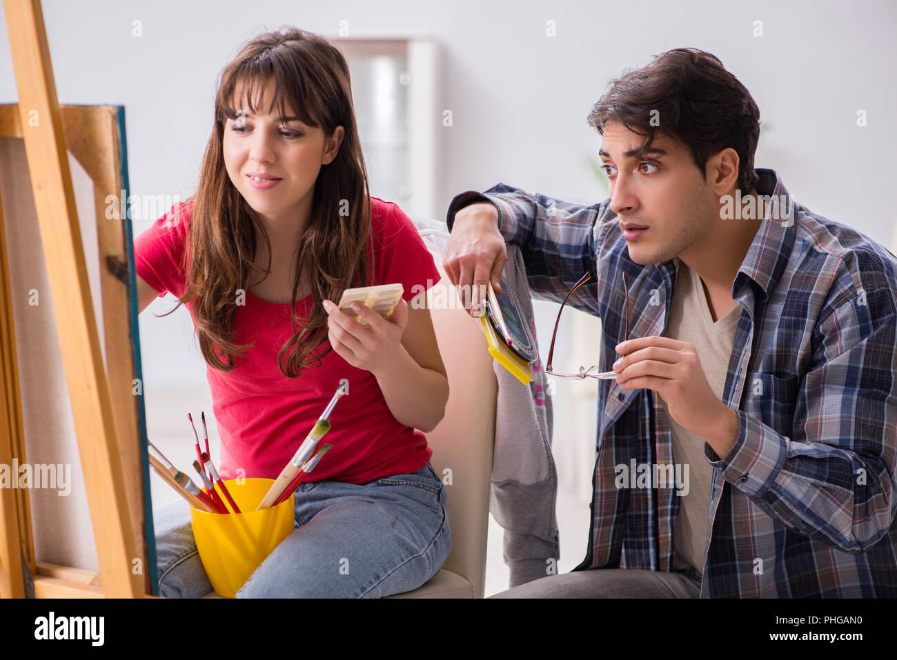 Artist coaching student in painting class in studio Stock Photo - Alamy