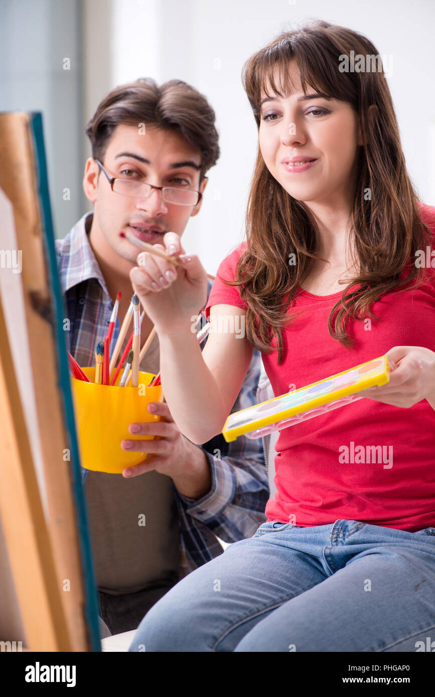 Artist coaching student in painting class in studio Stock Photo - Alamy