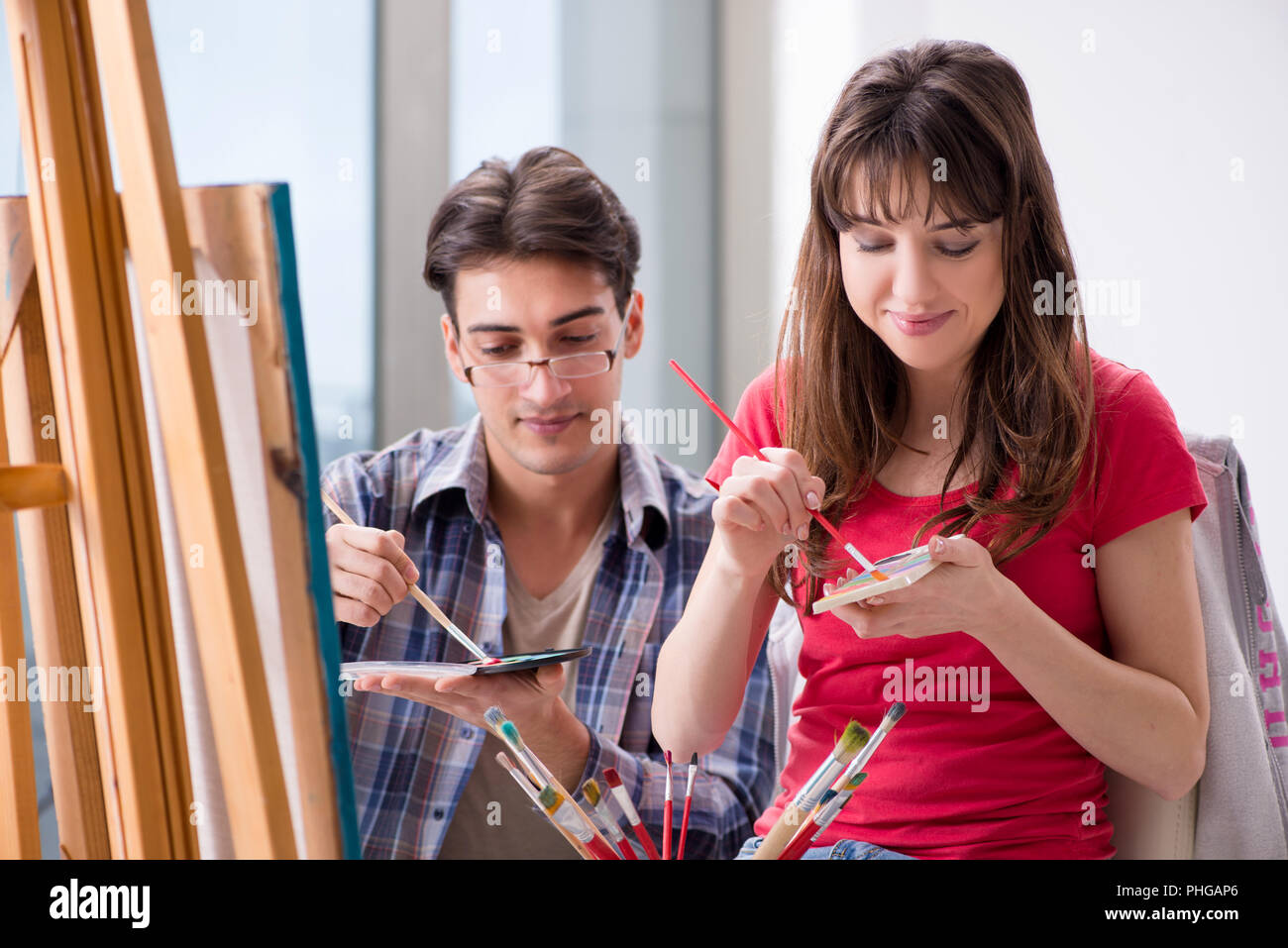 Artist coaching student in painting class in studio Stock Photo - Alamy