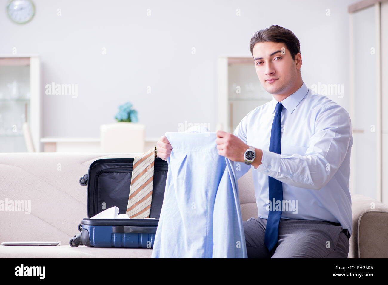 Businessman preparing packing for business trip Stock Photo - Alamy