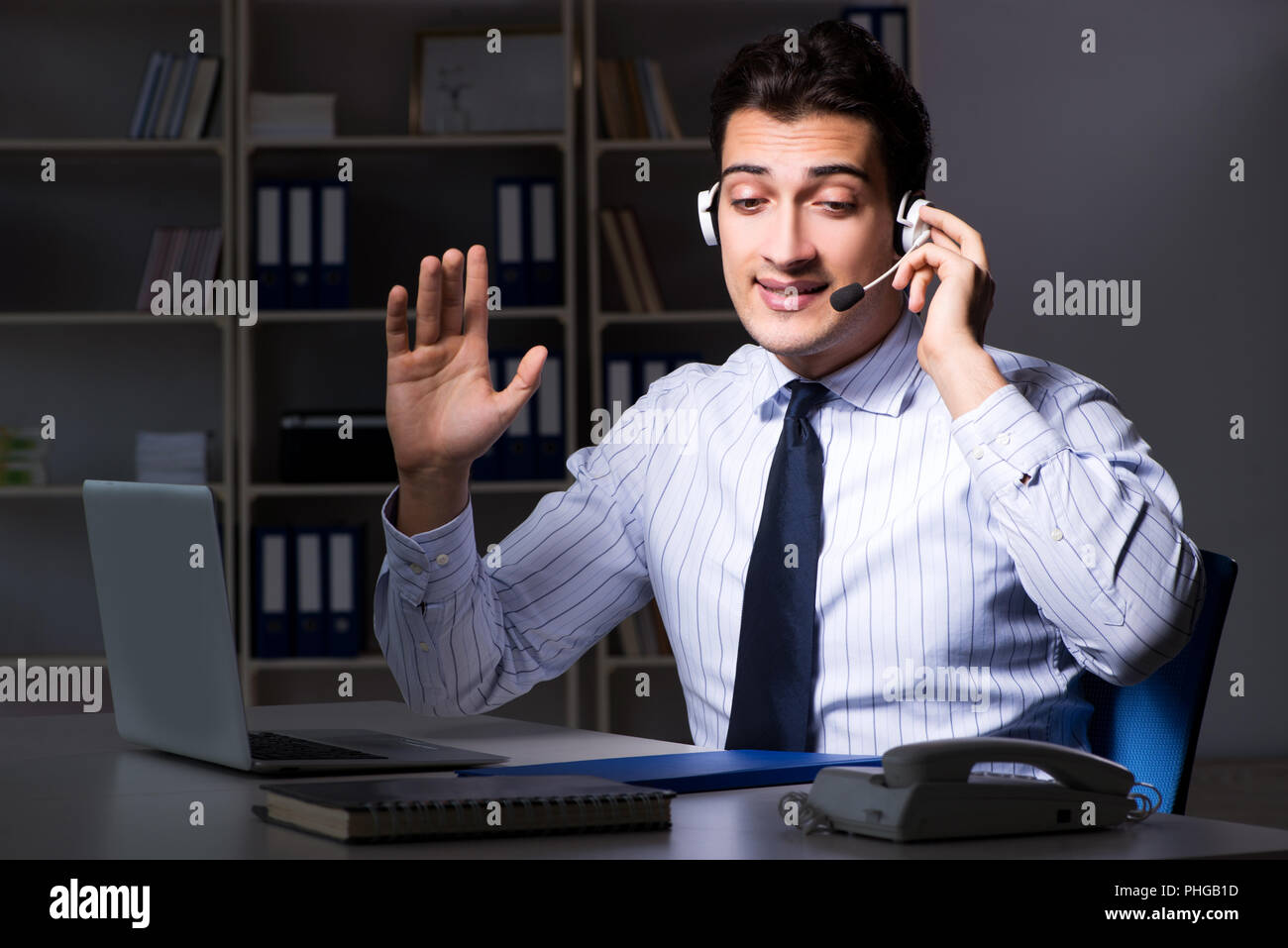 Call center operator talking to customer during night shift Stock Photo ...