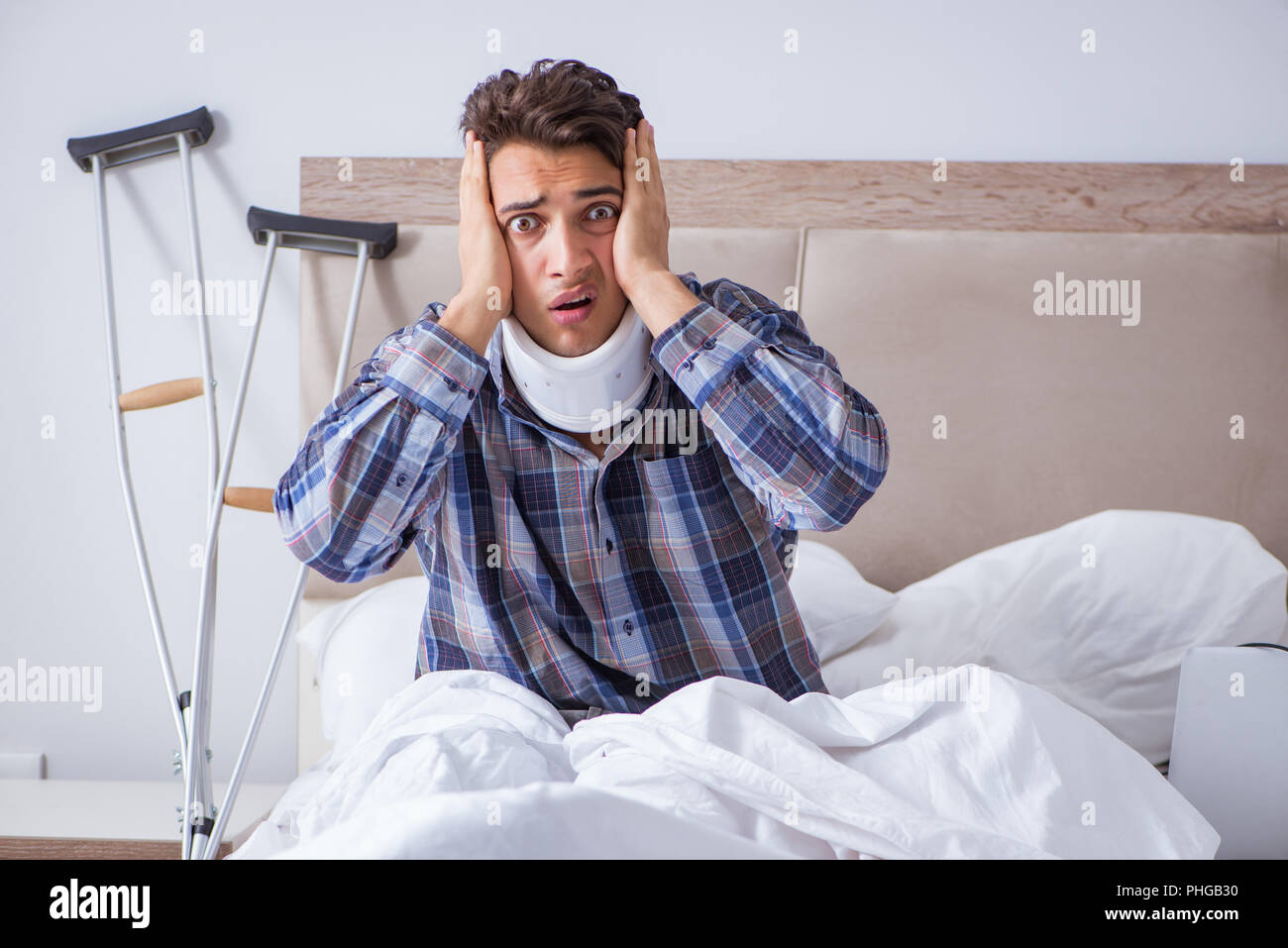 Injured man in bed at home with crutches Stock Photo - Alamy