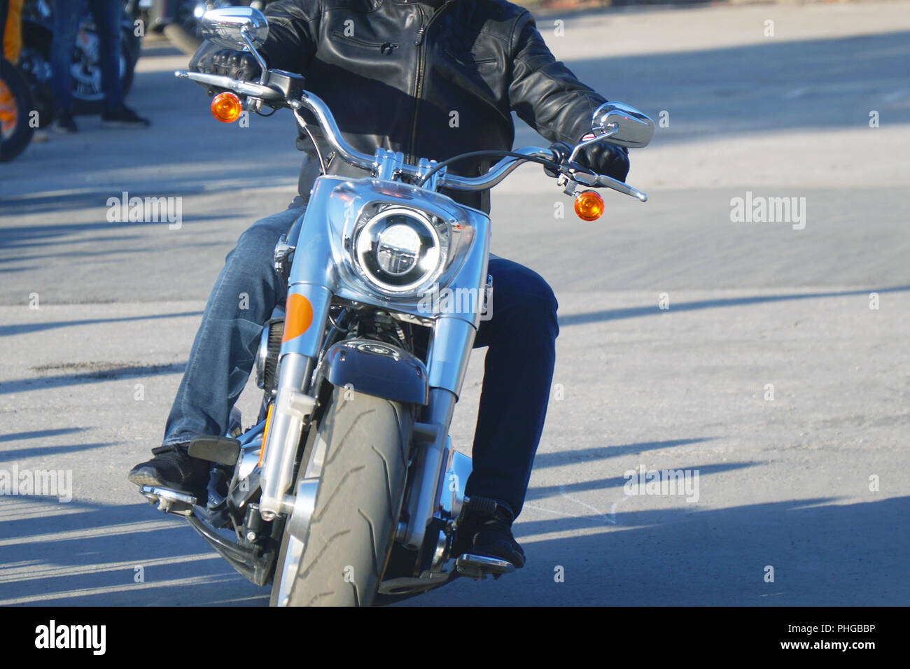 The biker in a leather jacket rides a motorcycle Stock Photo - Alamy