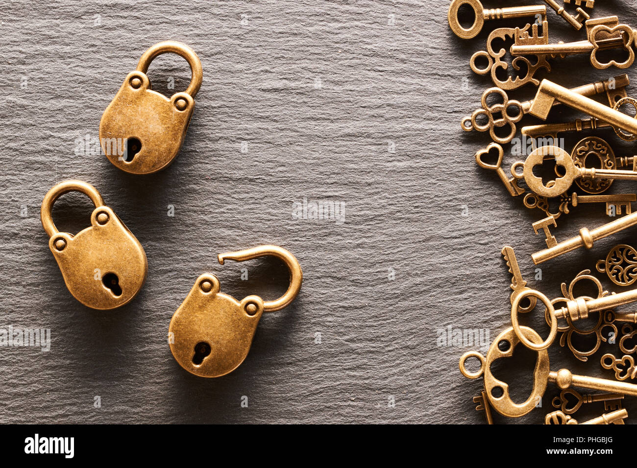 Various metal keys and locks on slate background Stock Photo - Alamy
