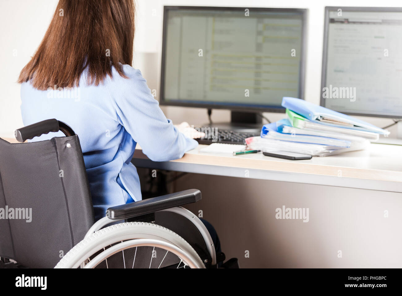 Invalid or disabled woman sitting wheelchair working office desk ...