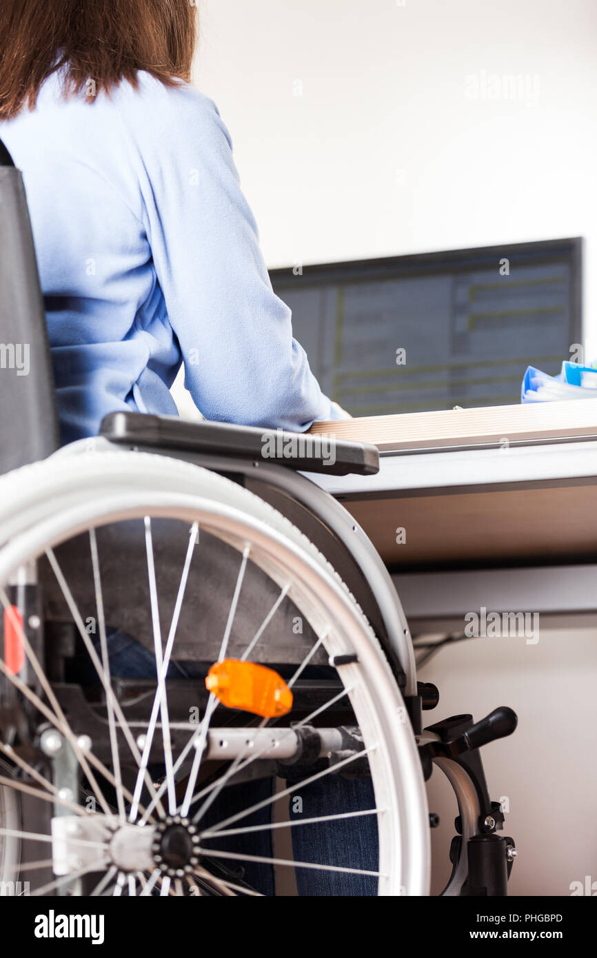 Invalid or disabled woman sitting wheelchair working office desk ...