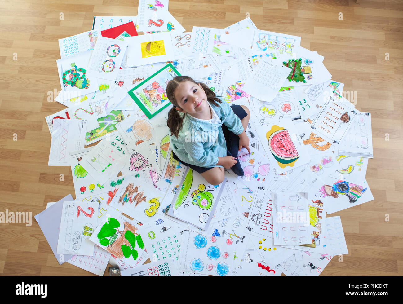Happy five years student over her whole year homework. Overhead shot ...